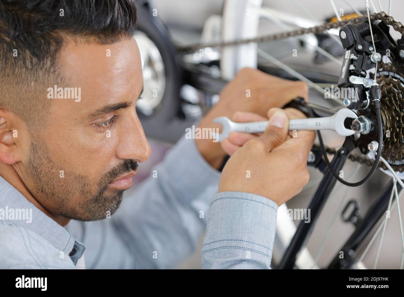 repairman fixing central cog of wheel Stock Photo - Alamy