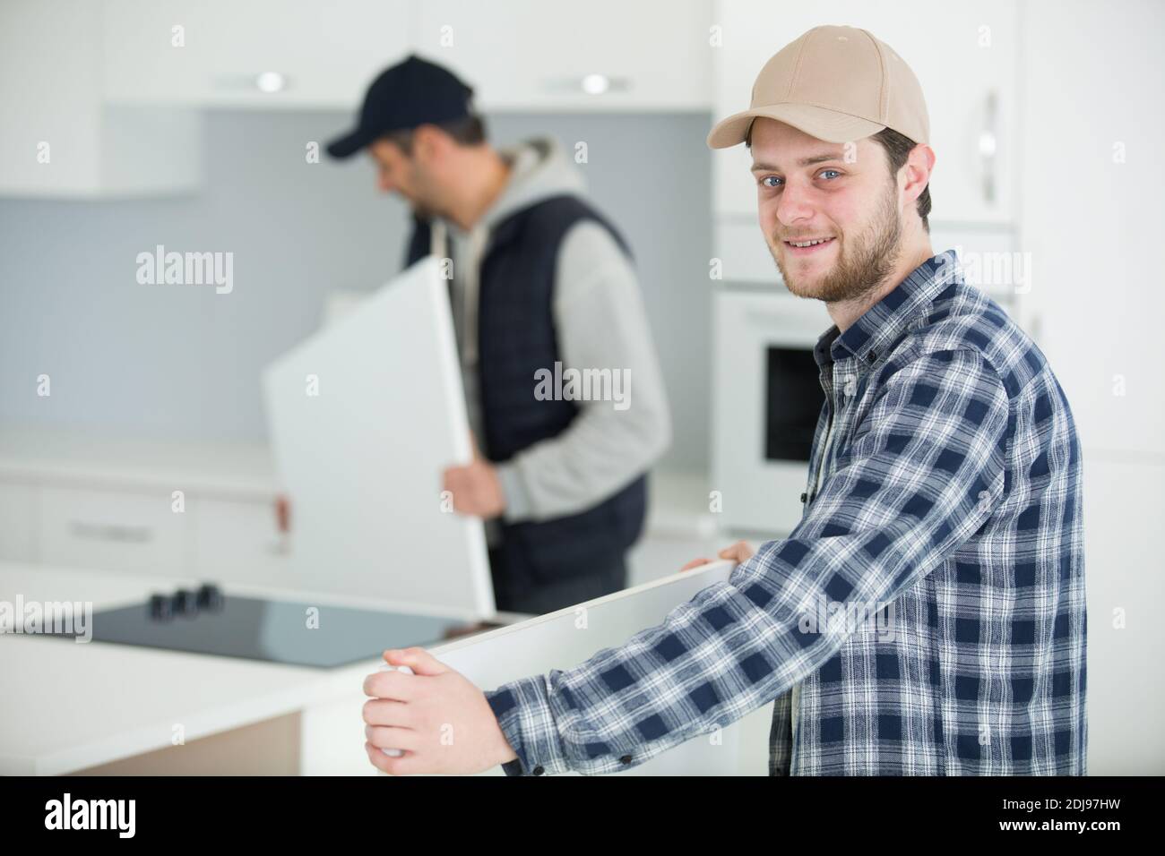 two men fitting a new kitchen Stock Photo - Alamy