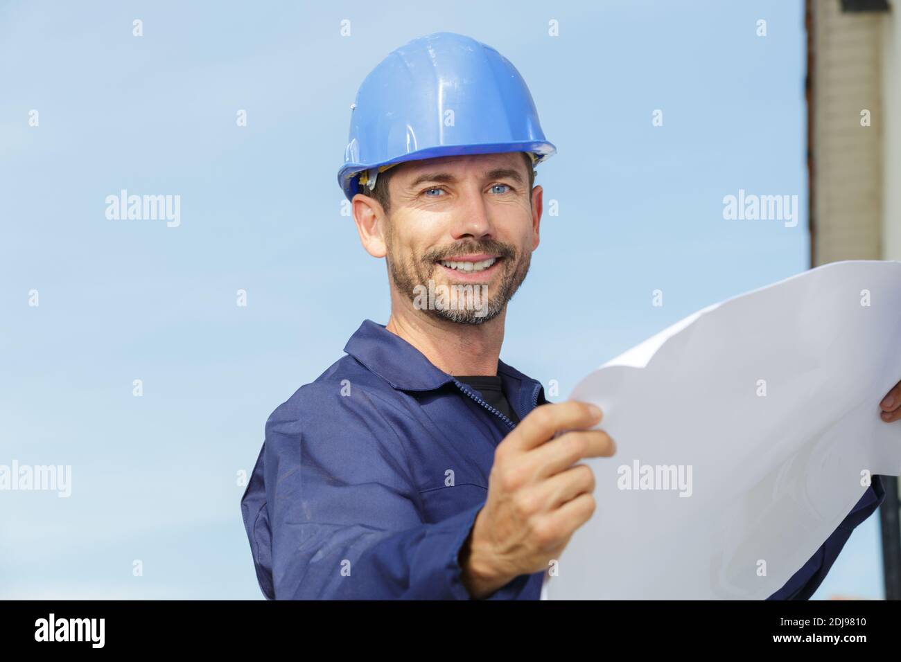 contractor man with helmet holding blueprints Stock Photo - Alamy