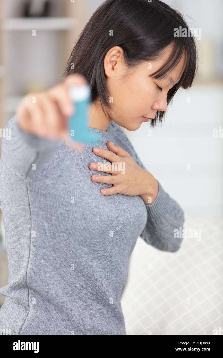 pretty woman holding her inhaler at home Stock Photo - Alamy