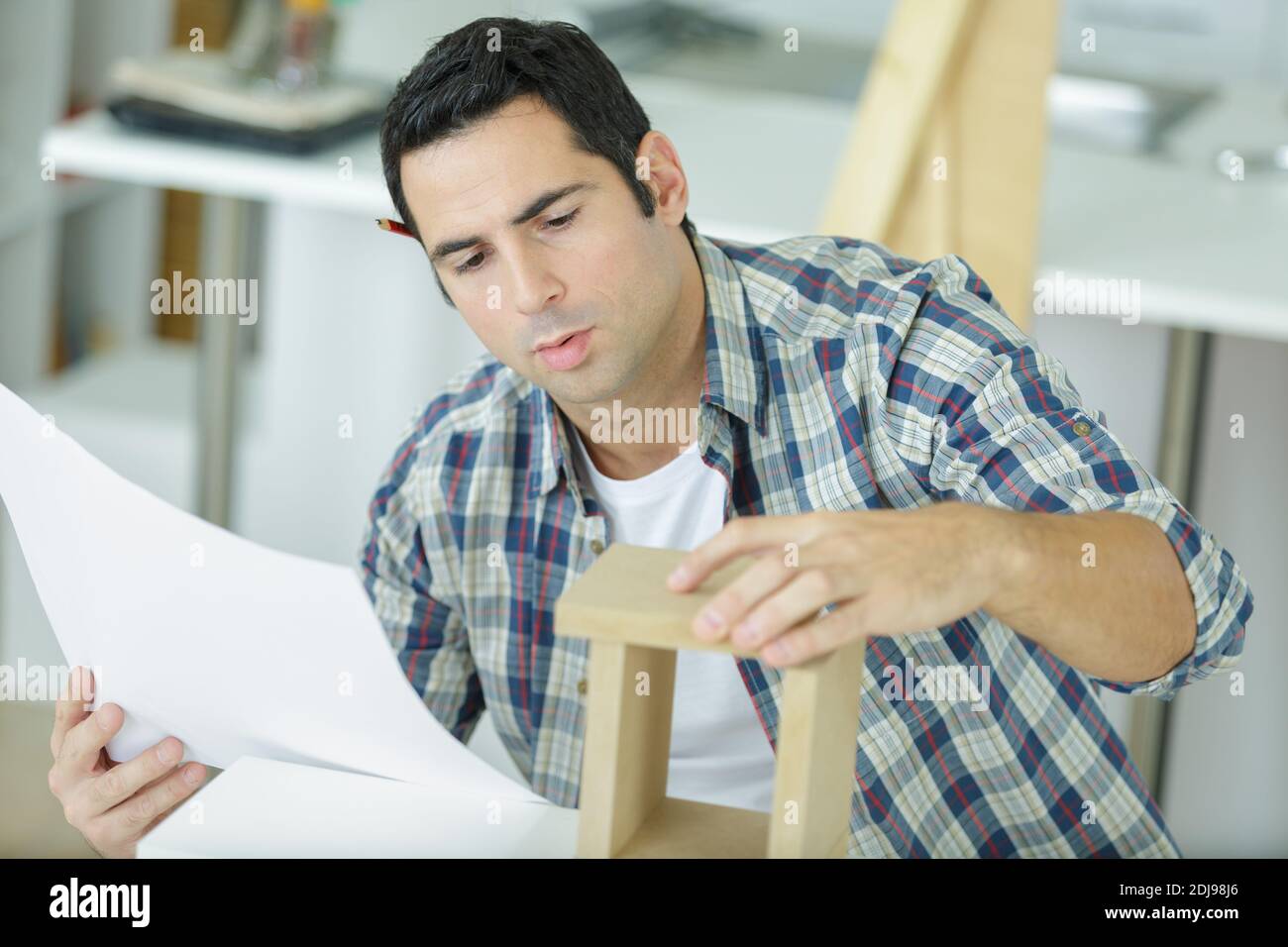 handyman reading an instruction manual with a frustrated expression ...