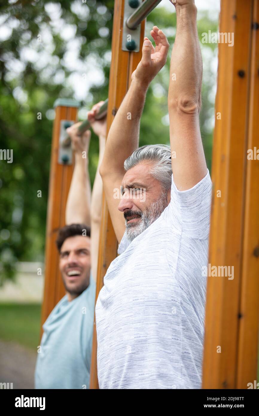 two strong and motivated young men doing dips exercise Stock Photo - Alamy