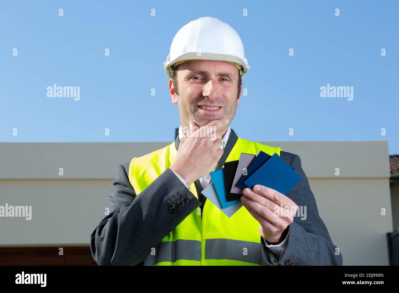 portrait of suited man holding sample colour tiles Stock Photo - Alamy
