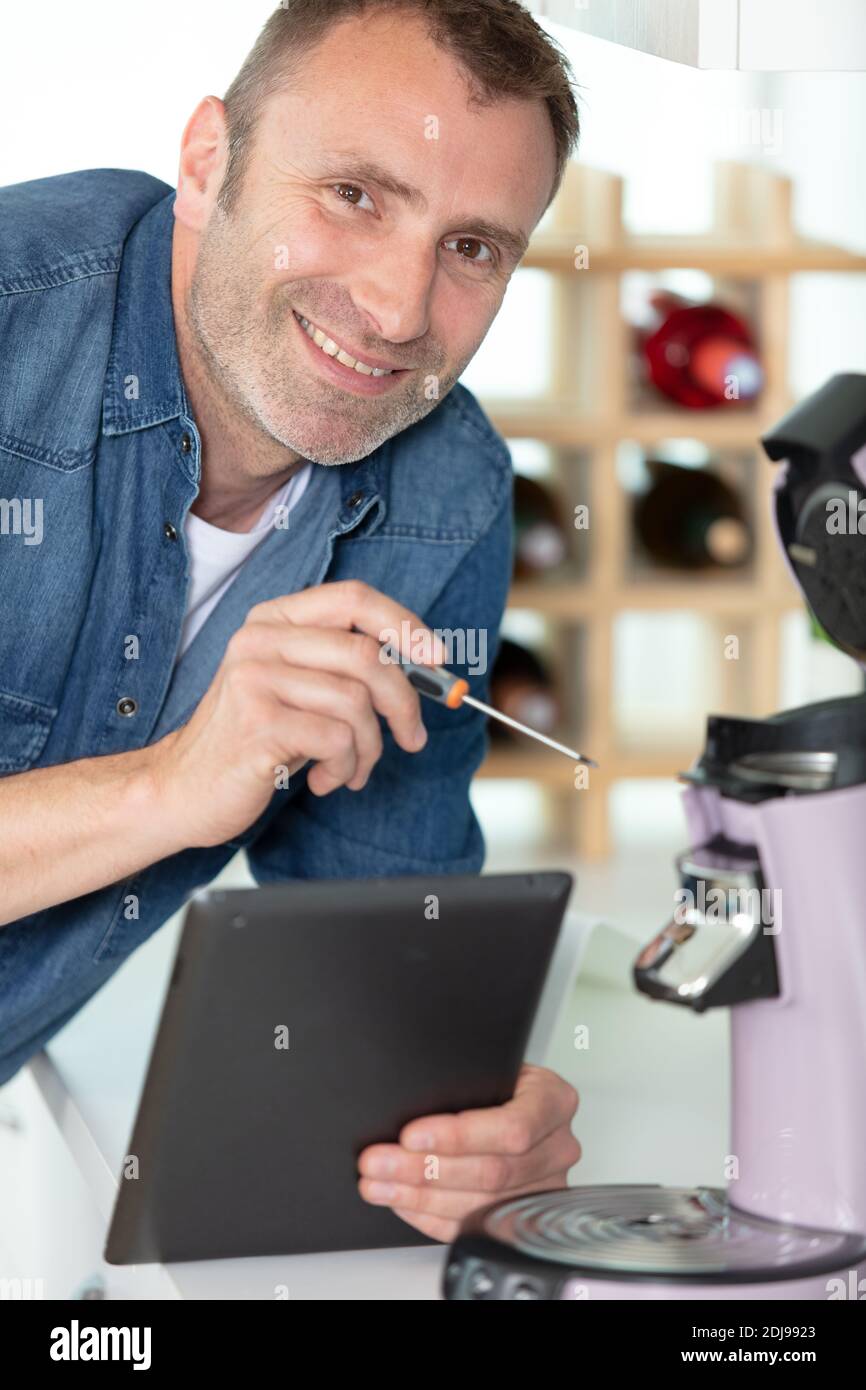 happy man repairing broken coffee machine Stock Photo - Alamy