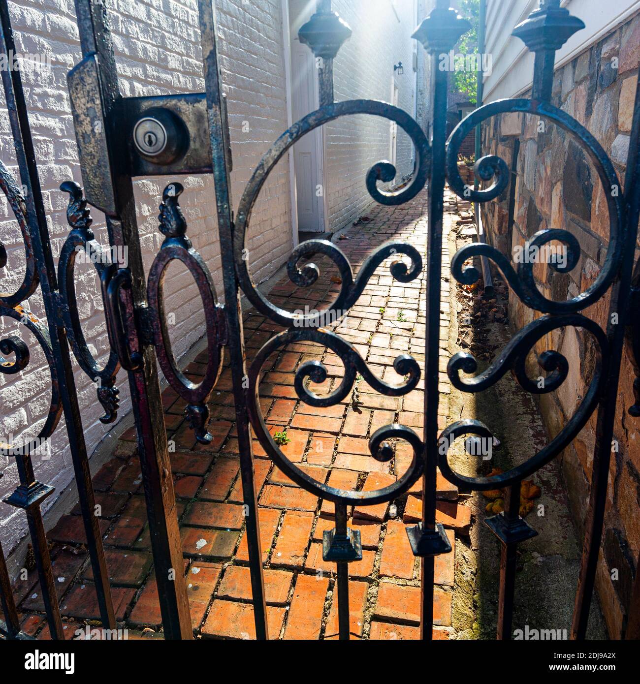 An abstract image of a narrow passageway behind locked gate. The ...
