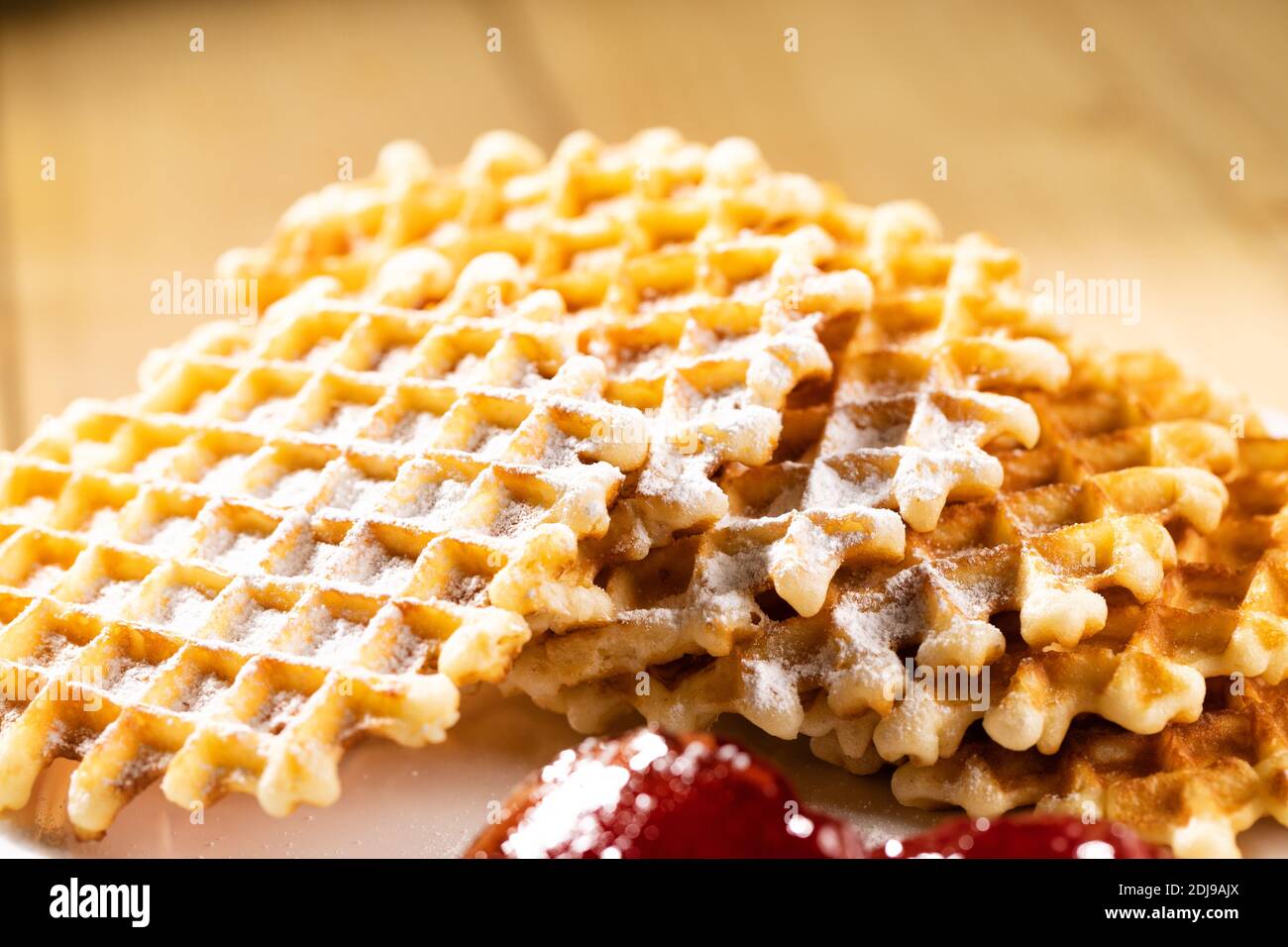 round belgian waffles on a white plate on a rustic wooden table Stock ...