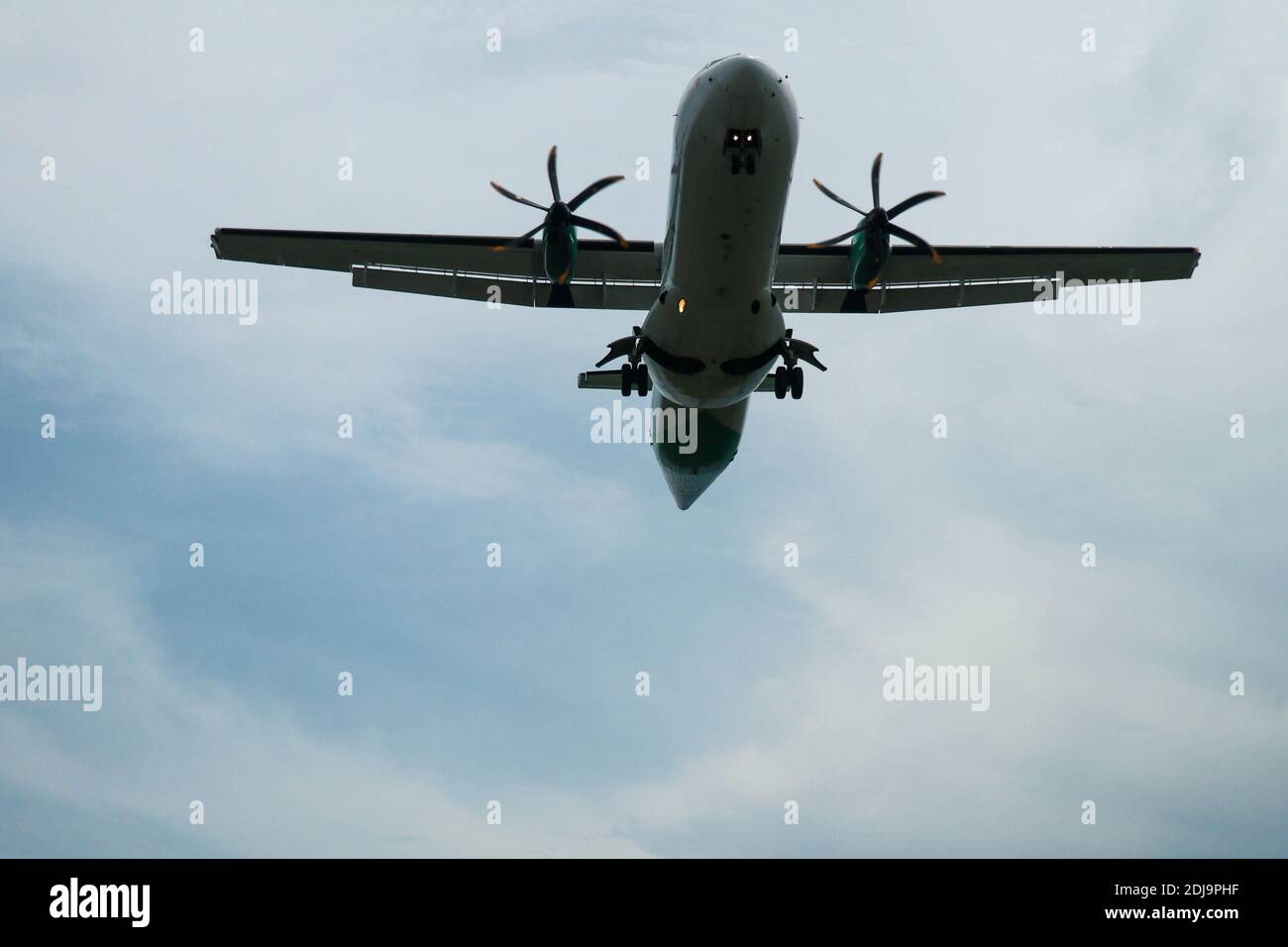 propeller airplane landing in cloudy sky. Propeller plane flying ...