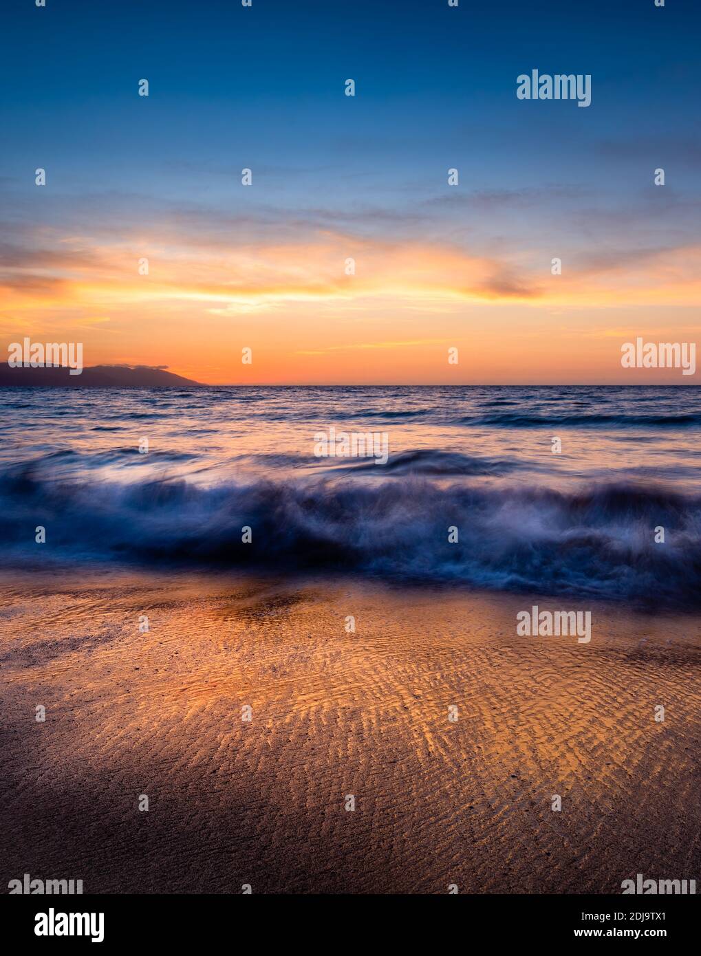 A Vertical Image of a Colorful Ocean Sunset With a Wave Breaking on ...
