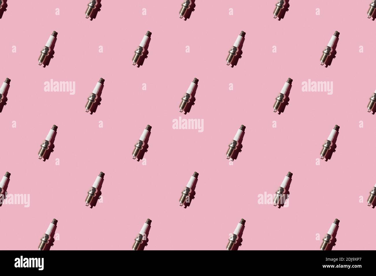 Spark plug pattern on a pink background Stock Photo - Alamy