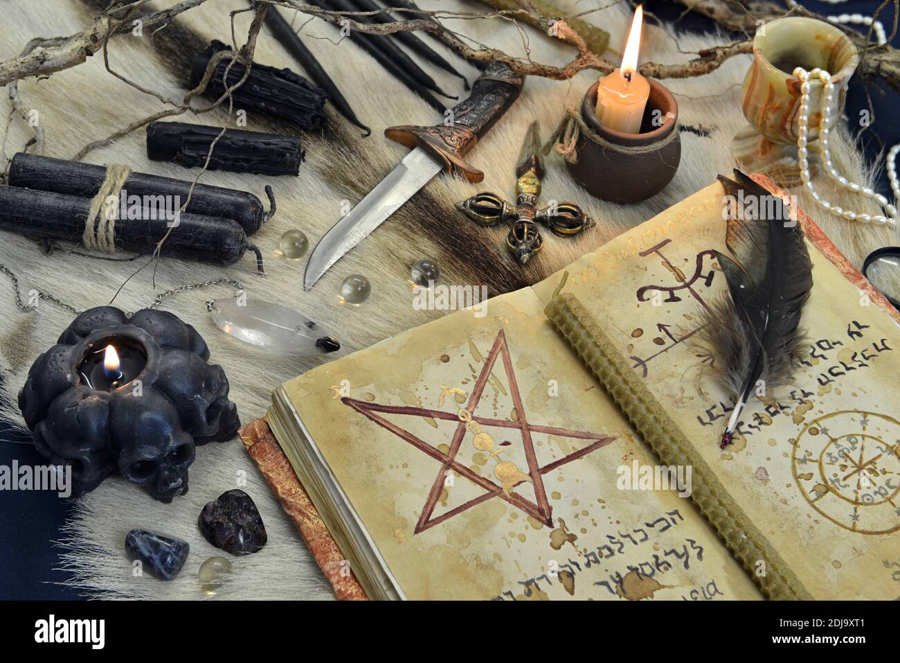 Still life with black magic grimoire book, burning candles and ritual ...