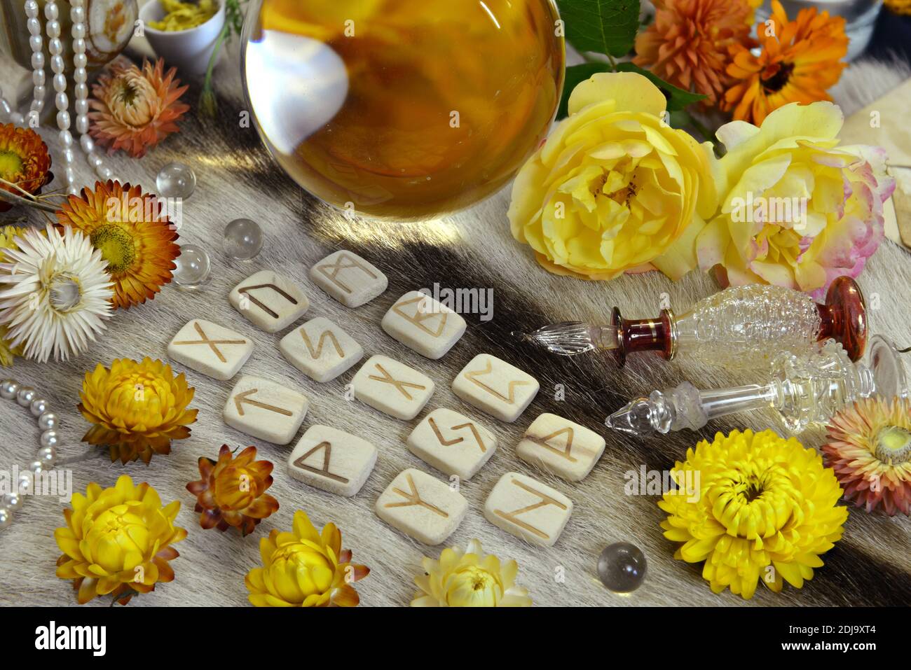 Still life with white wooden runes, yellow flowers and magic crystal ...