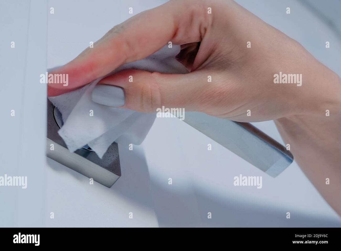 Woman cleaning door handle with wet wipe - disinfection concept Stock ...