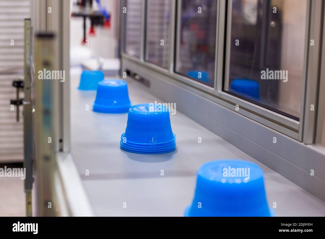 Pots on conveyor belt of plastic injection molding machine with robotic ...