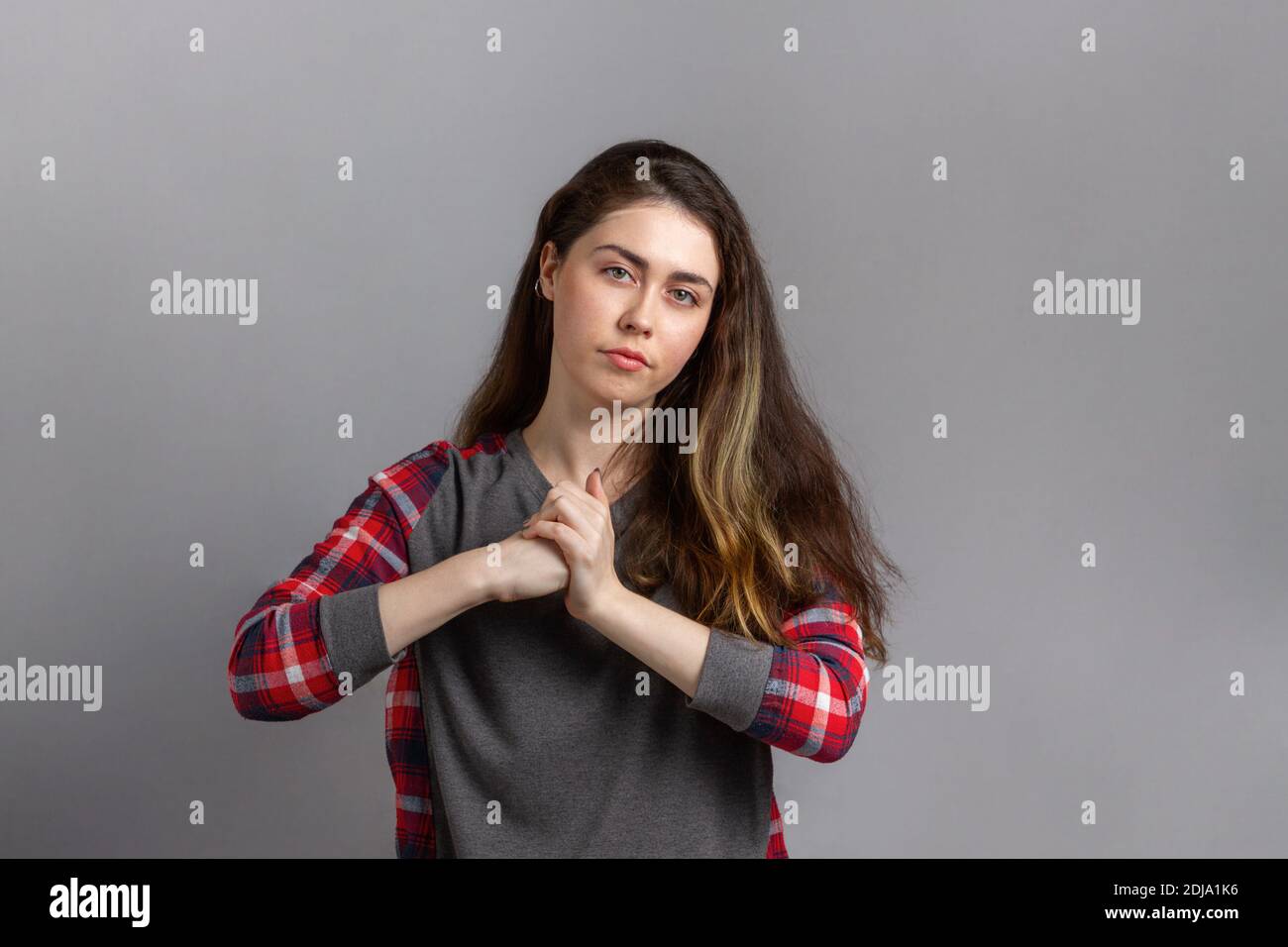 Emotions. A young woman with a discontented face rubs her fists ...