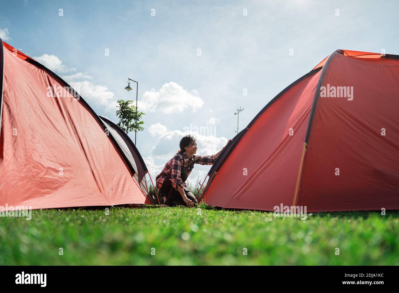 Portrait of a woman setting up a tent in the campground Stock Photo - Alamy