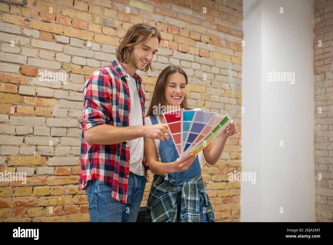 Young couple looking at color palette and choosing the wall color Stock ...