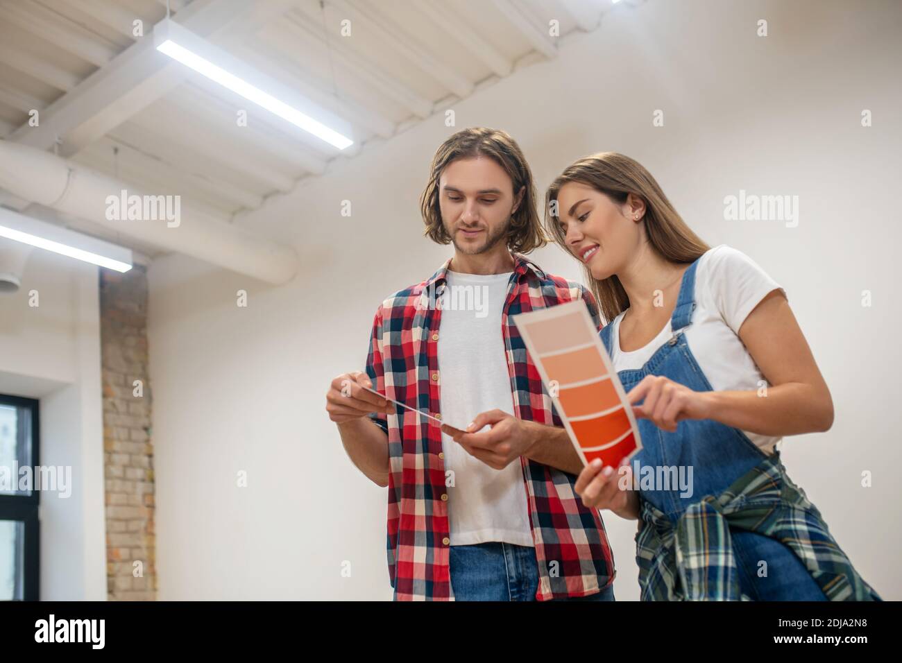 Young couple looking at color palette and discussing the wall color ...