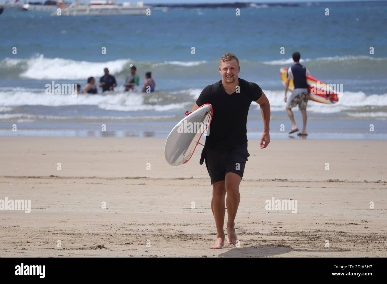 Surfer running on beach Stock Photo - Alamy