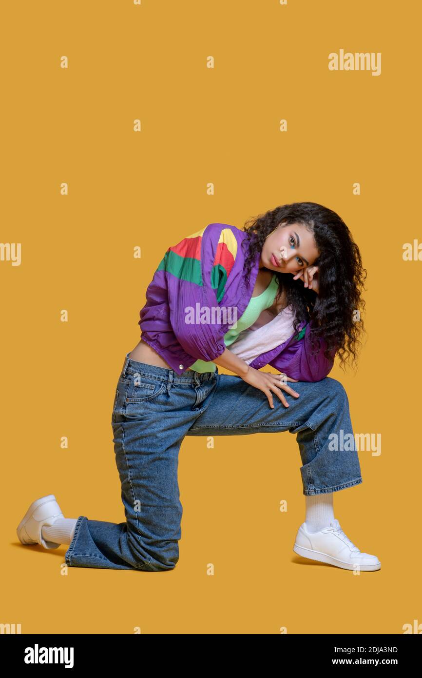 Pretty dark-haired young girl in jeans looking sad Stock Photo - Alamy