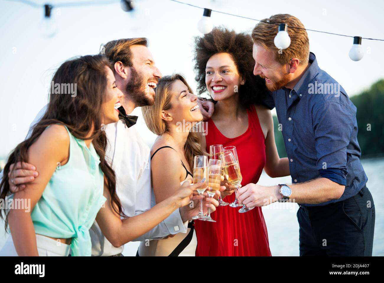 Group of happy friends partying and toasting drinks Stock Photo - Alamy
