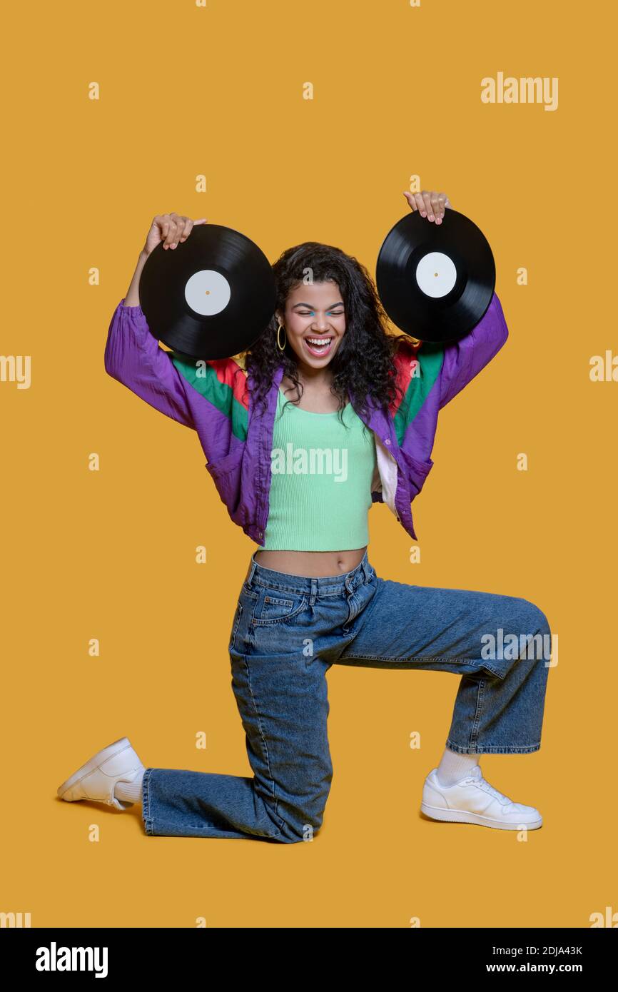 Cute dark-haired young girl holding records and having fun Stock Photo ...