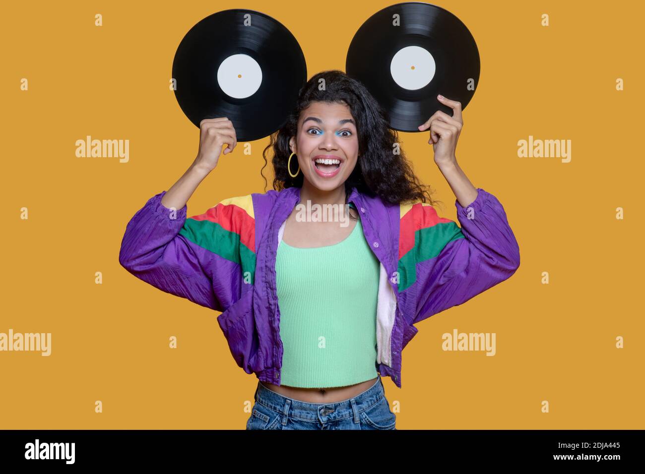 Cute dark-haired young girl holding records and having fun Stock Photo ...