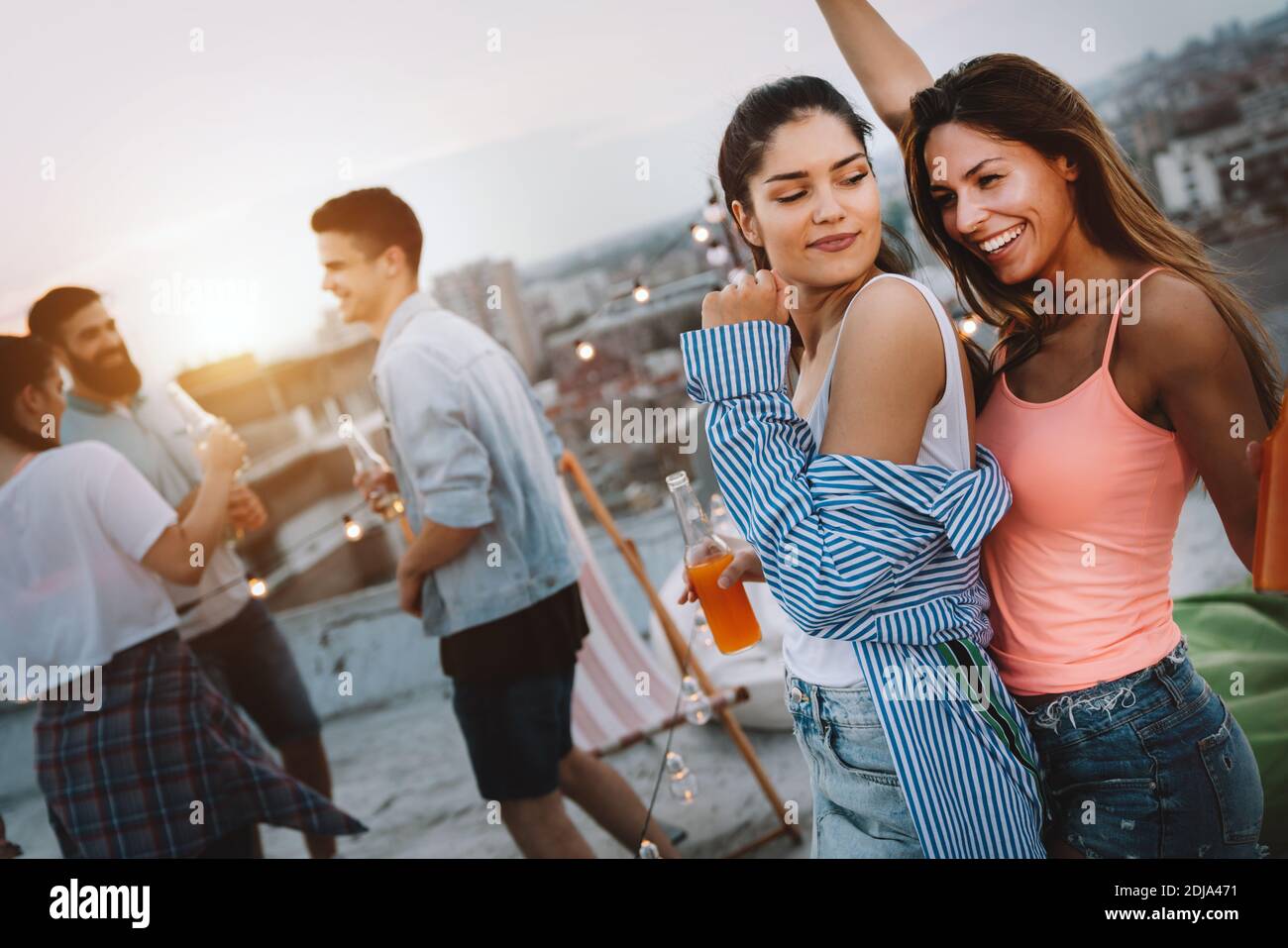 Friends having fun and drinking cocktails outdoor on a rooftop get ...