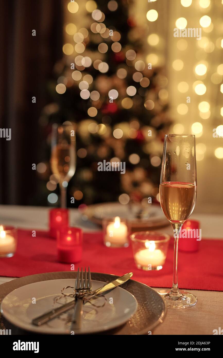 Close-up of dining table served with flutes, plates and silverware ...