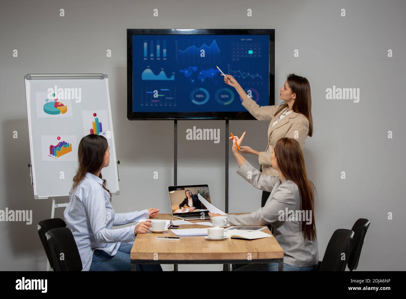 Graphs, month report on screen. Young women talking, working in ...