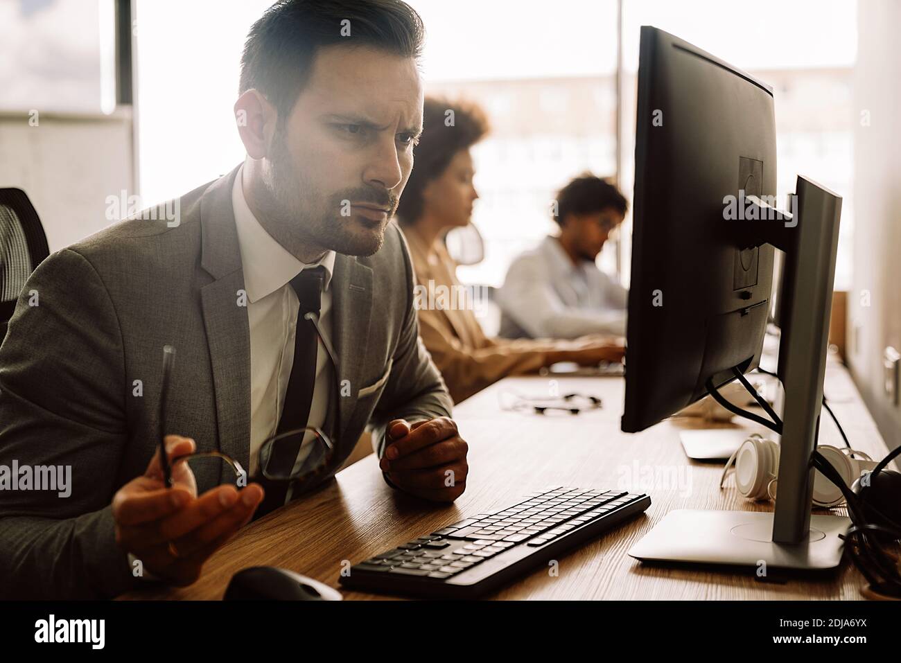 Serious businessman thinking hard of problem solution working late in ...