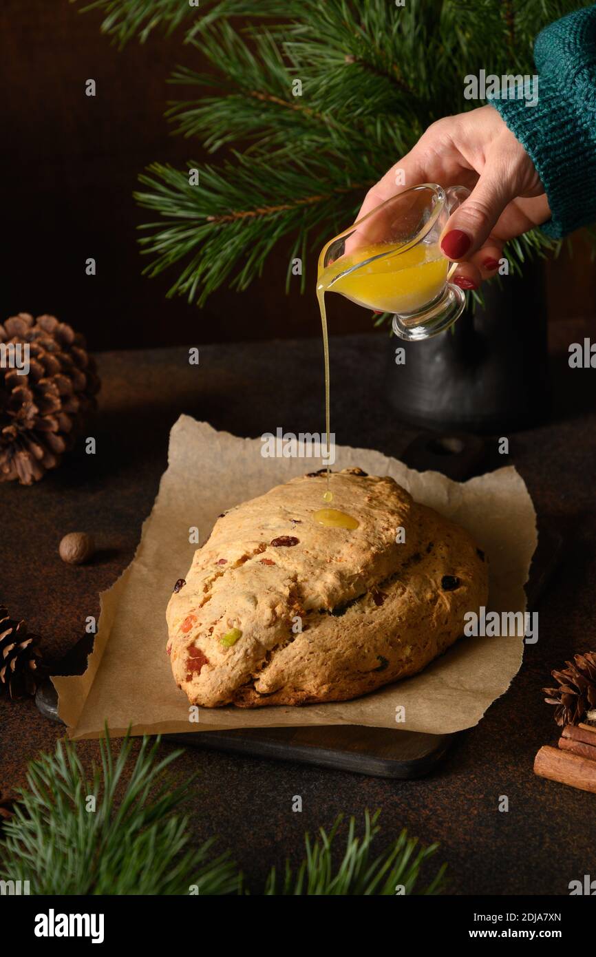 Pouring butter on Christmas stollen on brown background. on brown ...