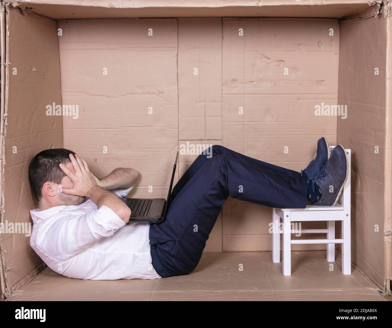 broken businessman in a cardboard office, stress and depression from ...