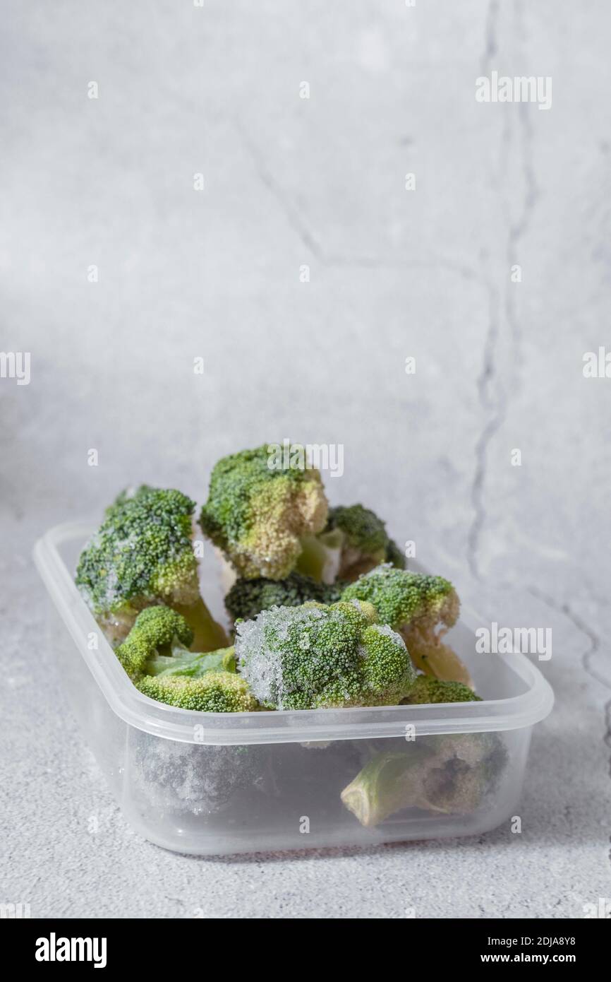 selective focus. frozen broccoli in a clear container. copyspace. light ...