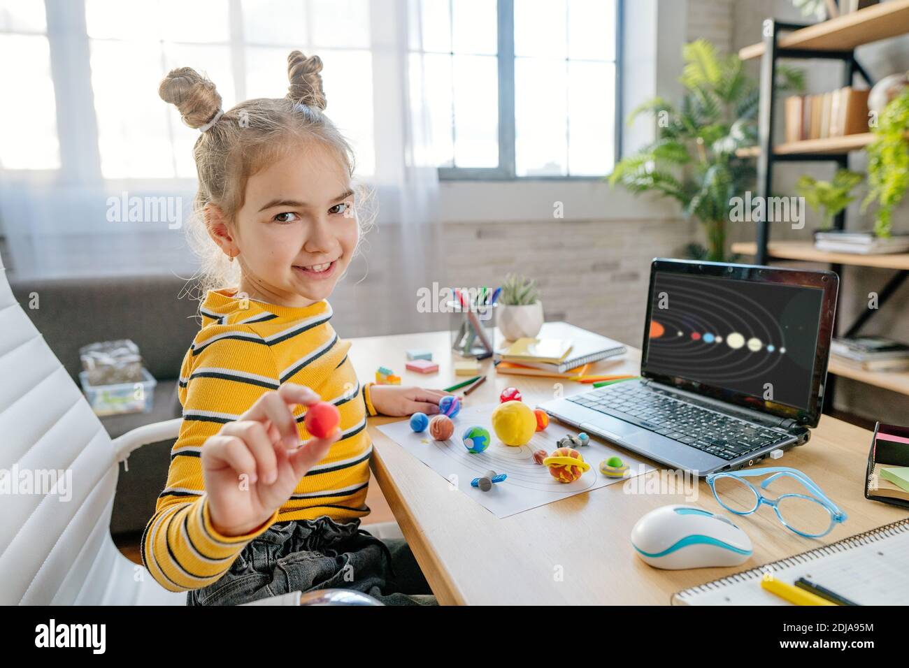 Little 8 years old girl using laptop to study online planets of Solar ...