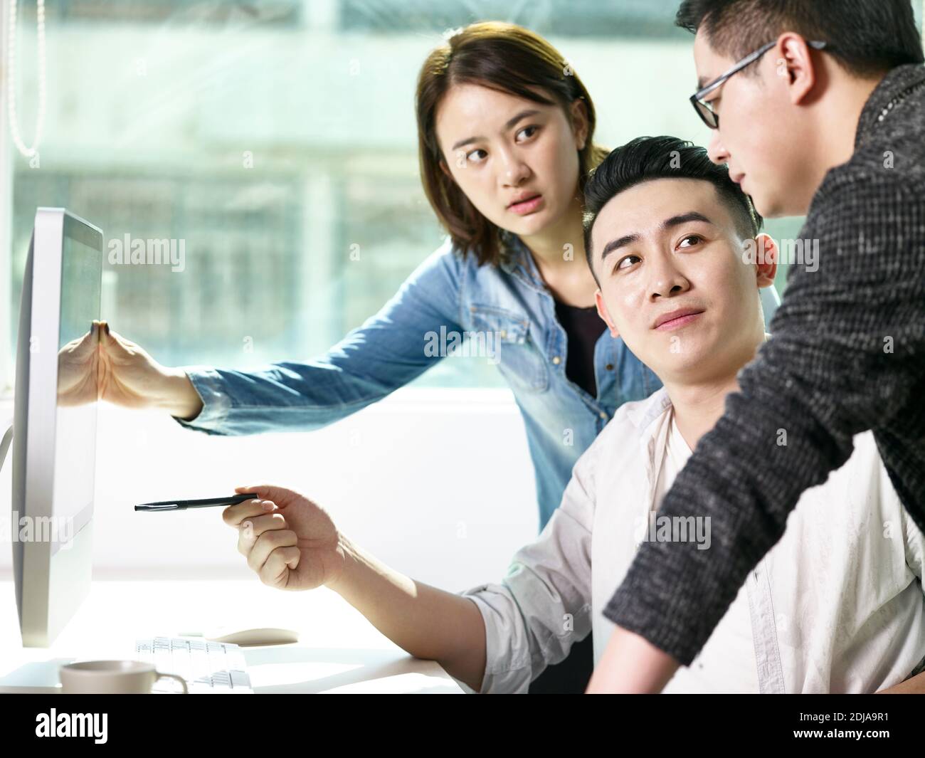 team of young asian people discussing business in office using desktop ...