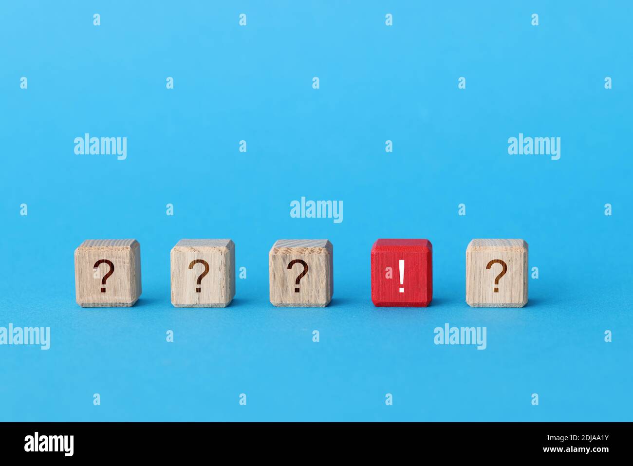 Red Wooden Cube With Exclamation Mark Lying Among Cubes With Question