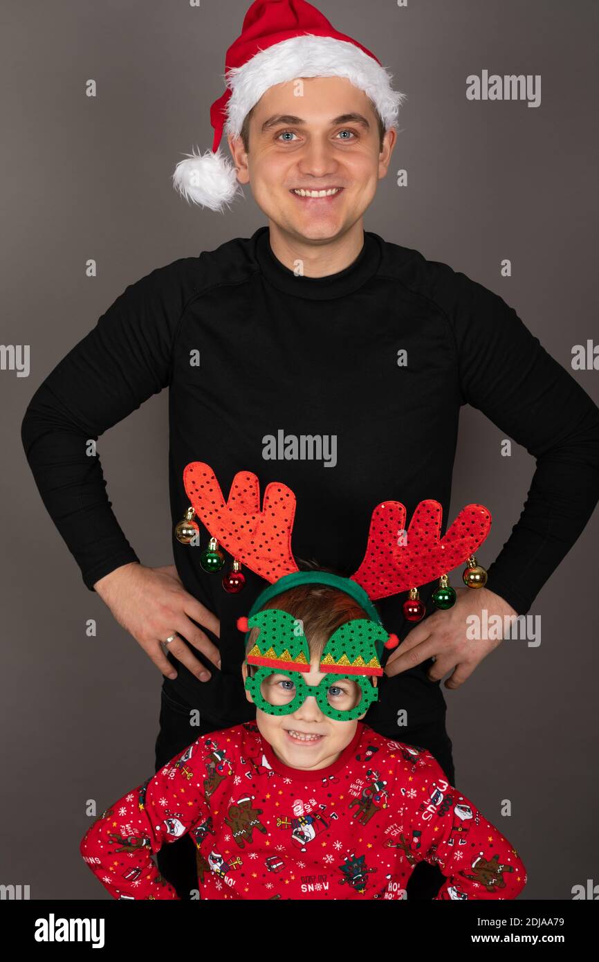 Handsome young father posing with his son, both wearing Christmas ...