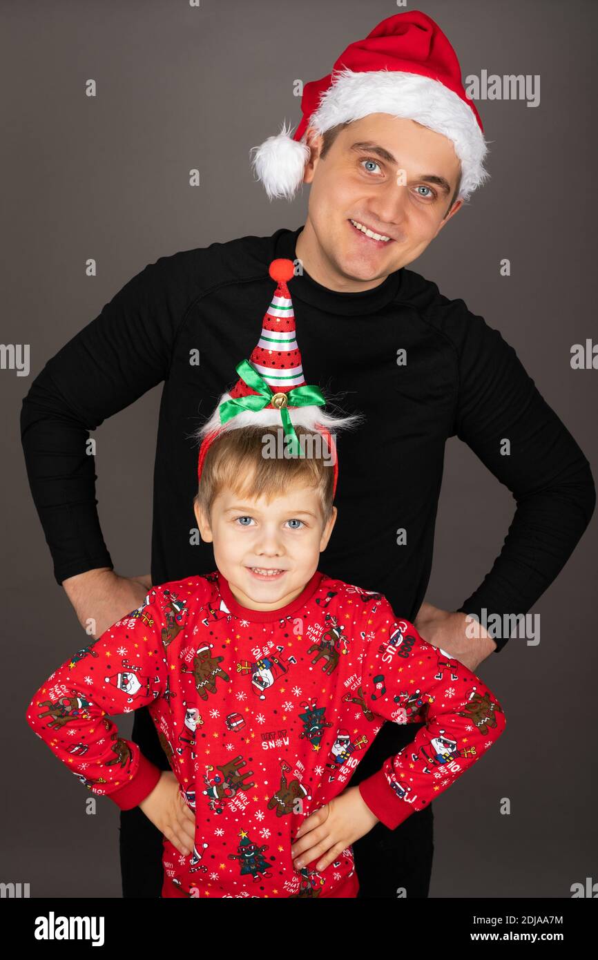 Handsome young father posing with his son, both wearing Christmas ...
