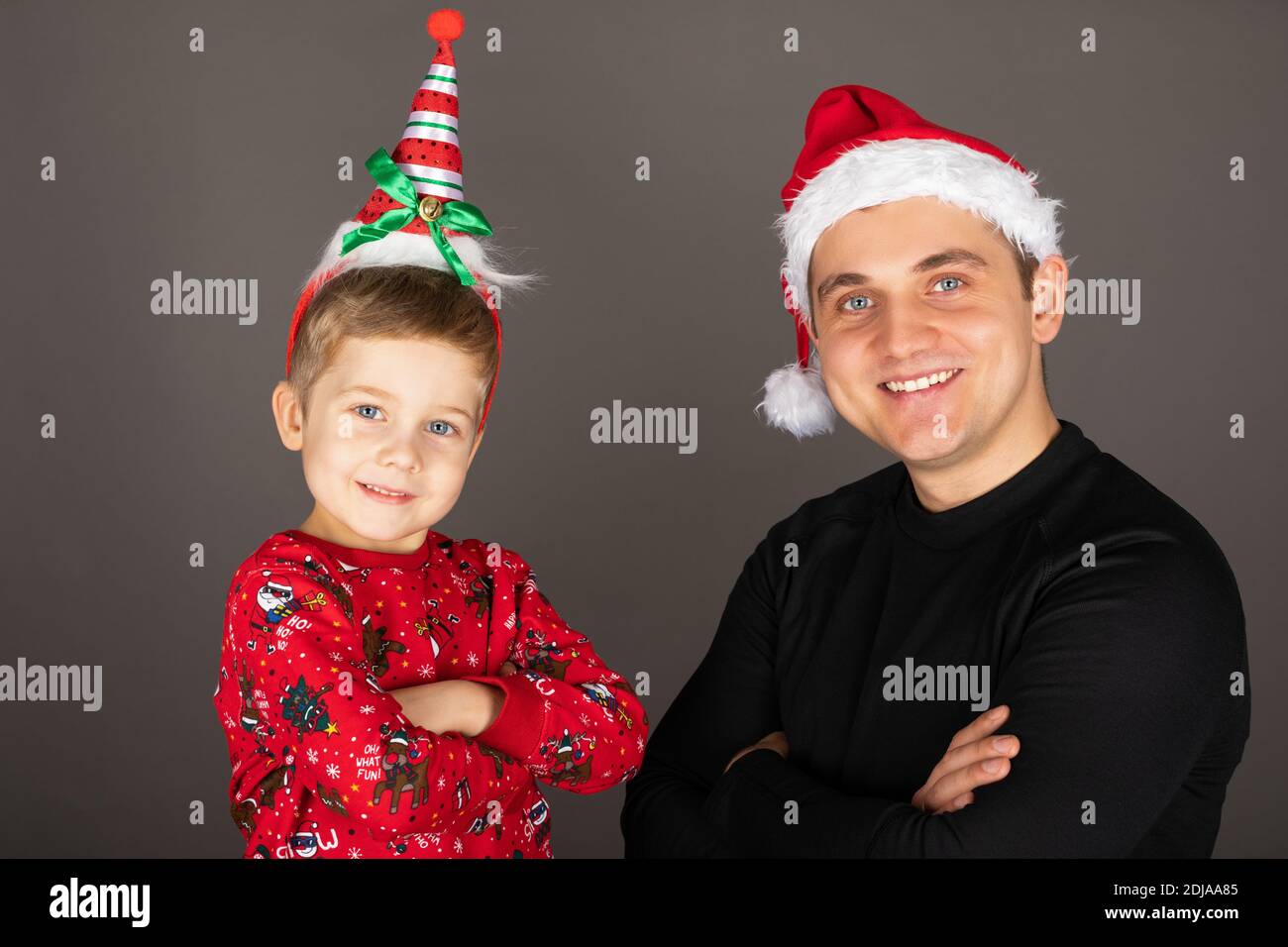 Handsome young father posing with his son, both wearing Christmas ...