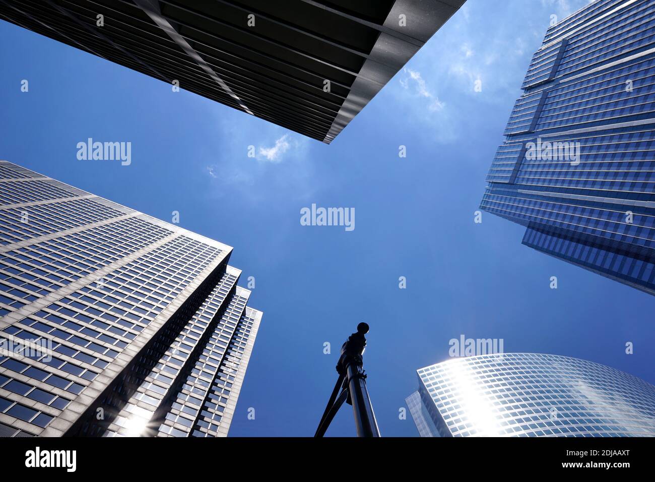 View from below on a blue sky between tall buildings. Part of the ...
