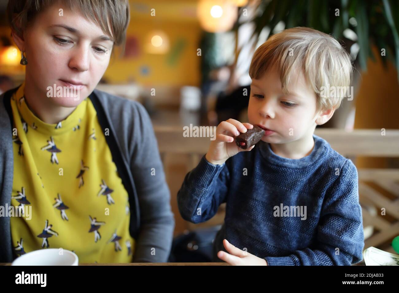 Child eating cake biscuits in a cafe Stock Photo - Alamy