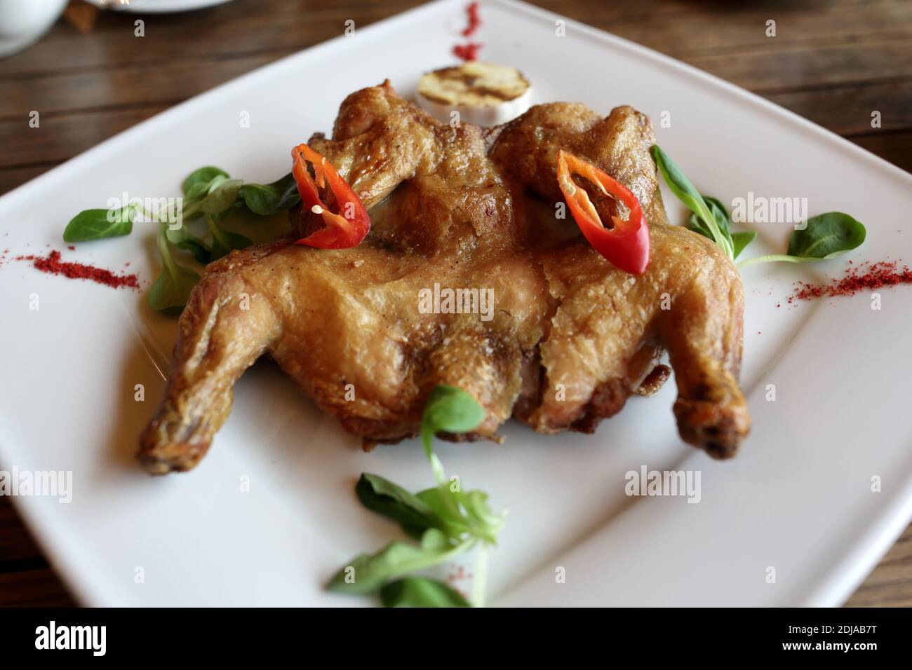 Chicken tobacco on white plate in georgian restaurant Stock Photo - Alamy