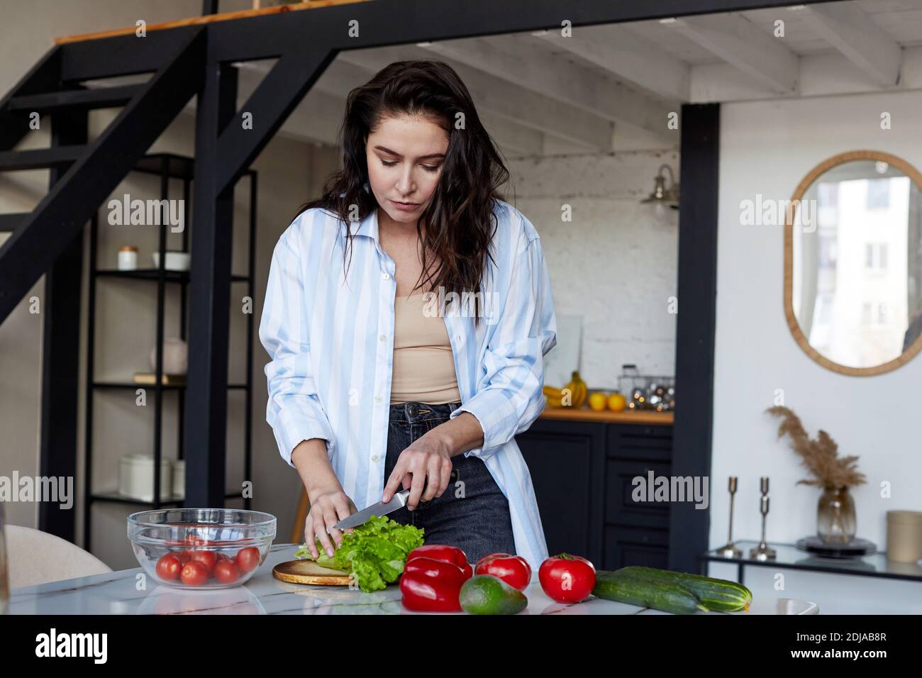 Brunette woman cooking in her cozy kitchen healthy food Stock Photo - Alamy