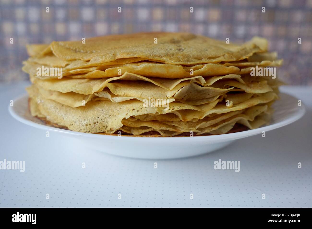 Thin crispy pancakes on a white plate. Russian traditional cuisine ...