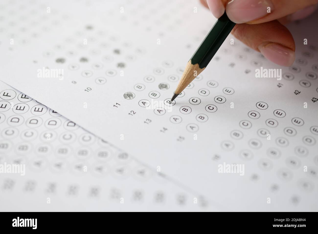 Woman solving tests and writing in pencil on paper closeup Stock Photo ...