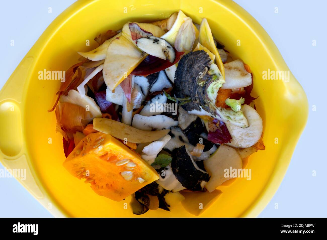 Vegetable compost in a yellow bowl on a white table. Caring for the ...