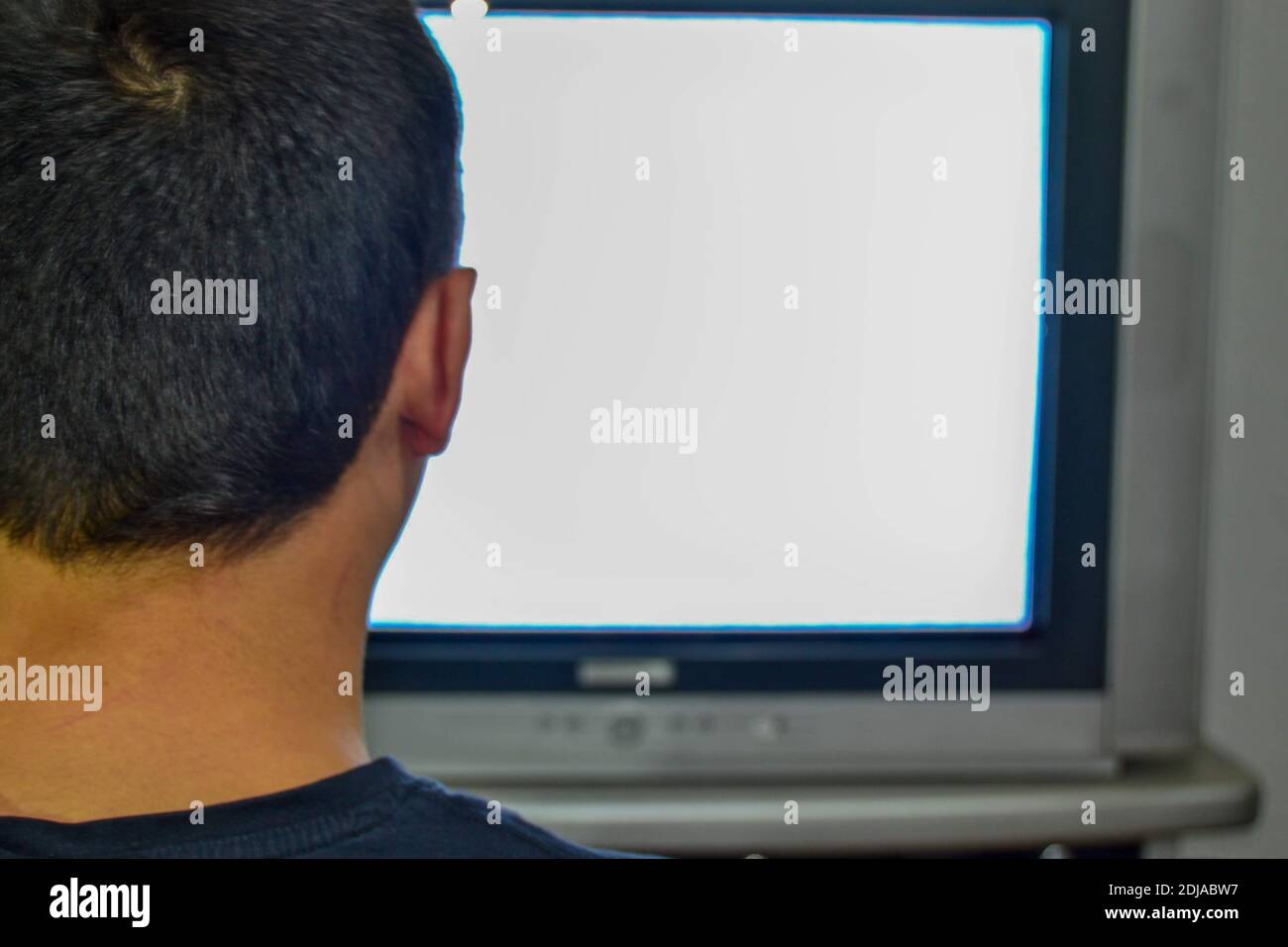 A alone man is watching television. Photo shows behind of the man and ...