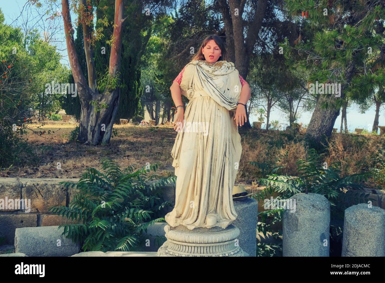 A young woman depicts a dead statue of ancient Greece or antique Rome ...