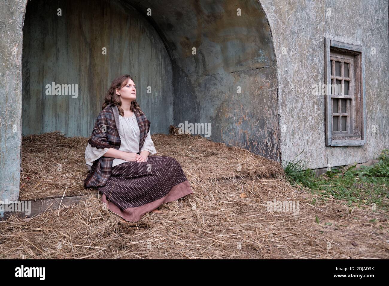 woman in vintage dress sitting in the hayloft - retro shawl, shirt and ...