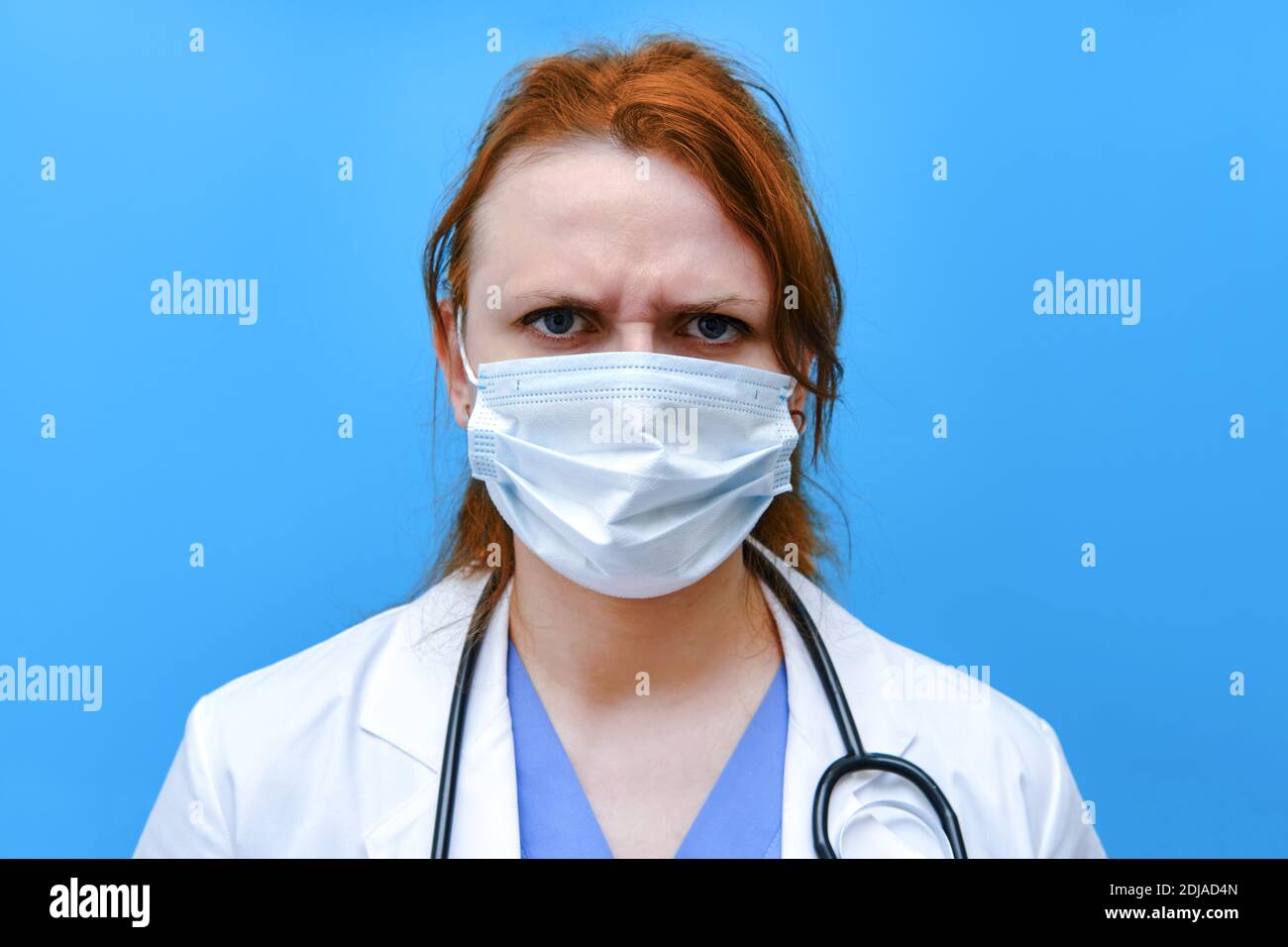 Portrait of a angry doctor woman, close up. Sad nurse in a blue uniform ...